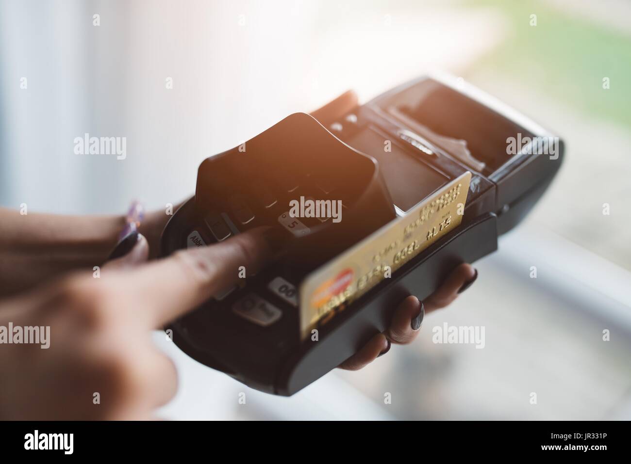 Consument entering pin code on card terminal during payment Stock Photo ...