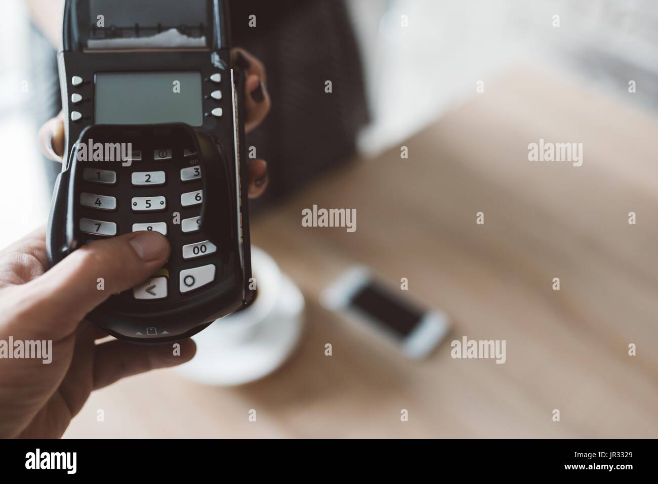Consument entering pin code on card terminal during payment Stock Photo ...
