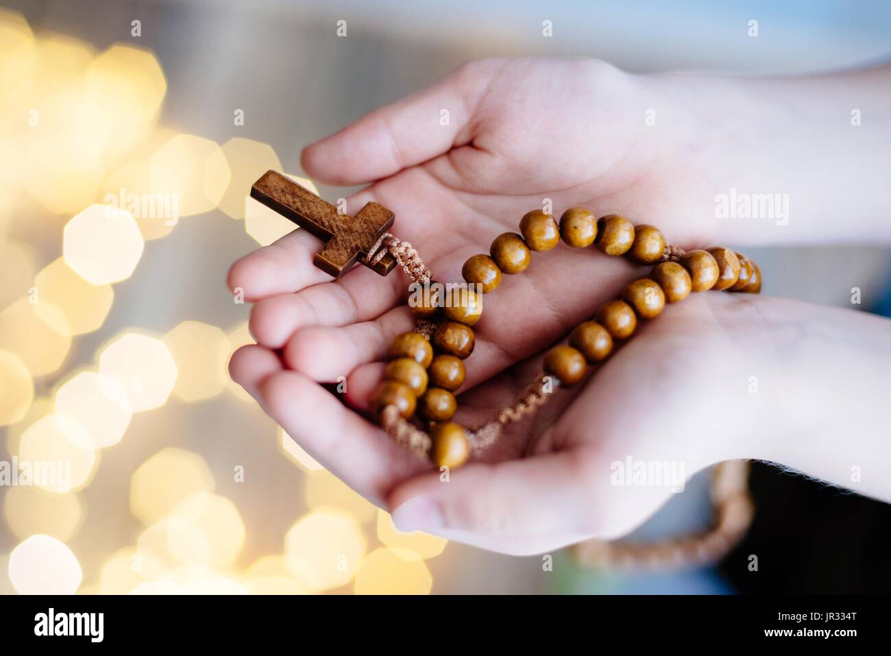 Little boy child praying and holding wooden rosary. More from this ...