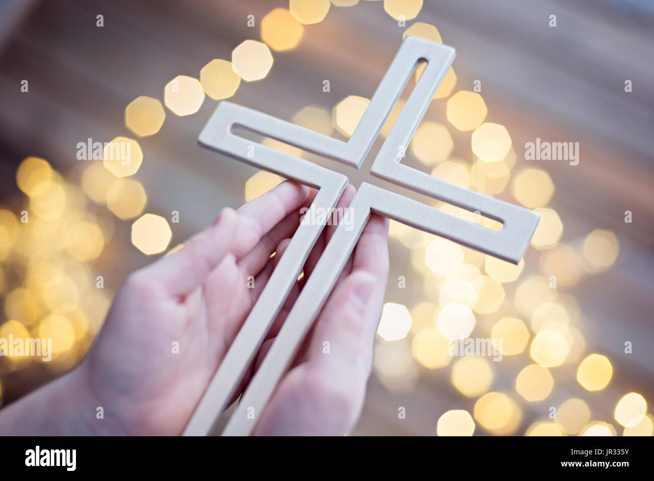 Little boy child praying and holding wooden crucifix Stock Photo - Alamy