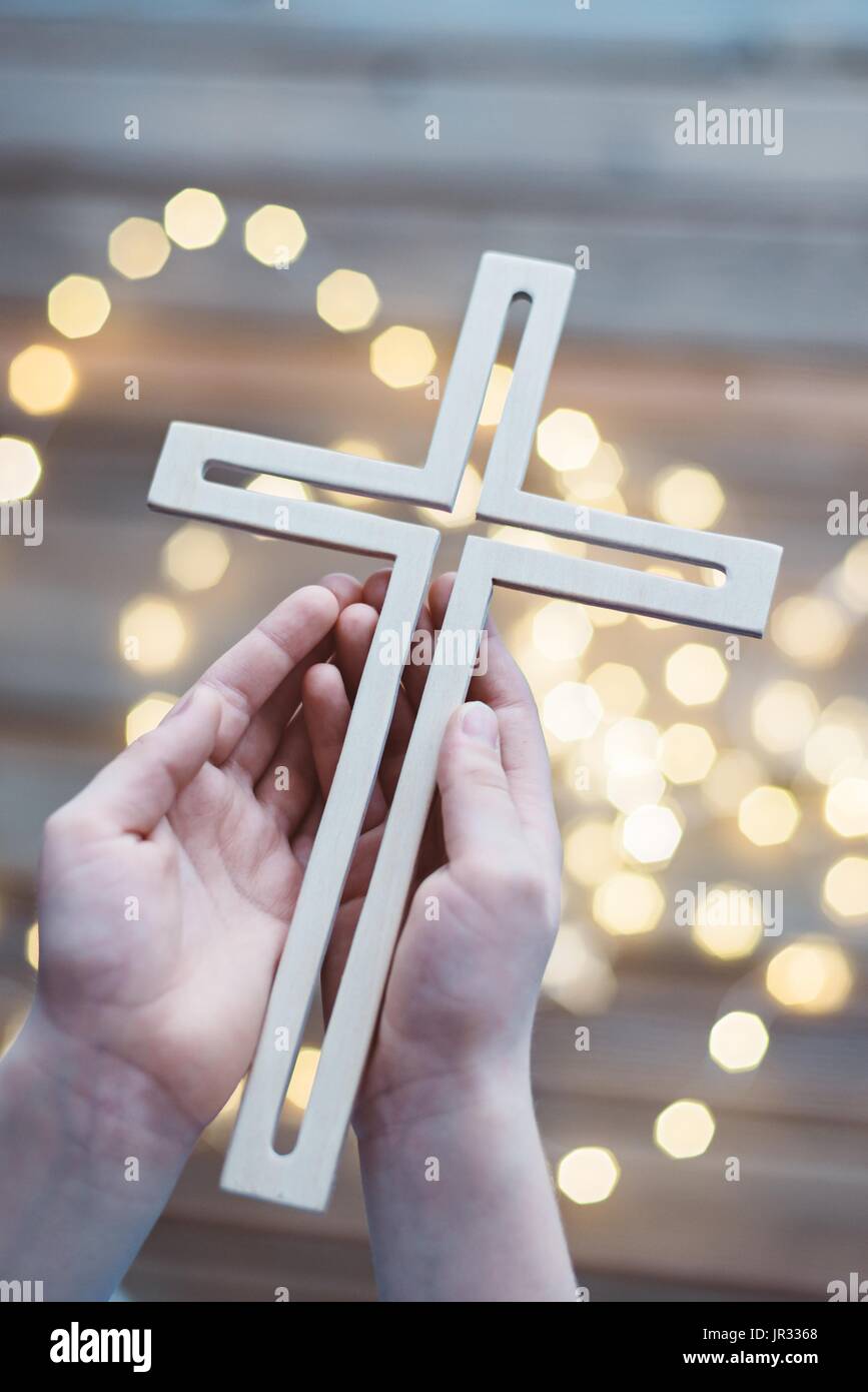 Little boy child praying and holding wooden crucifix Stock Photo - Alamy