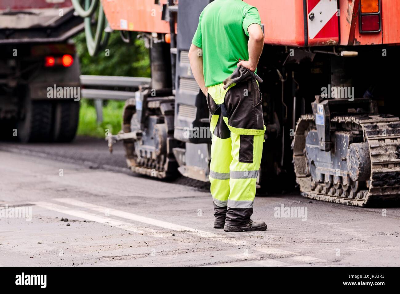 Road works. Worker uses the machine to remove upper layer of the ...