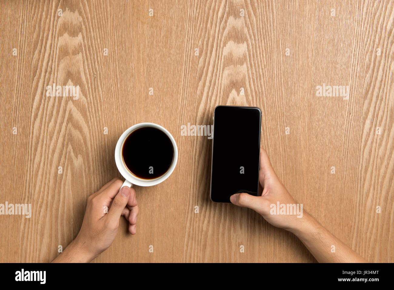 Man using smart phone sitting on table, hand holding smart phone ...