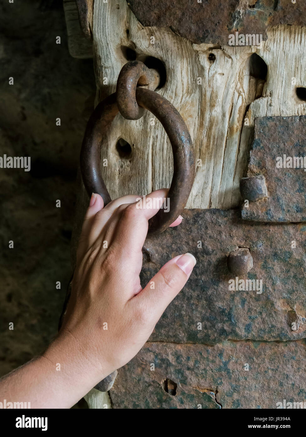 Woman's hand holds the ring of the ancient gate Stock Photo - Alamy