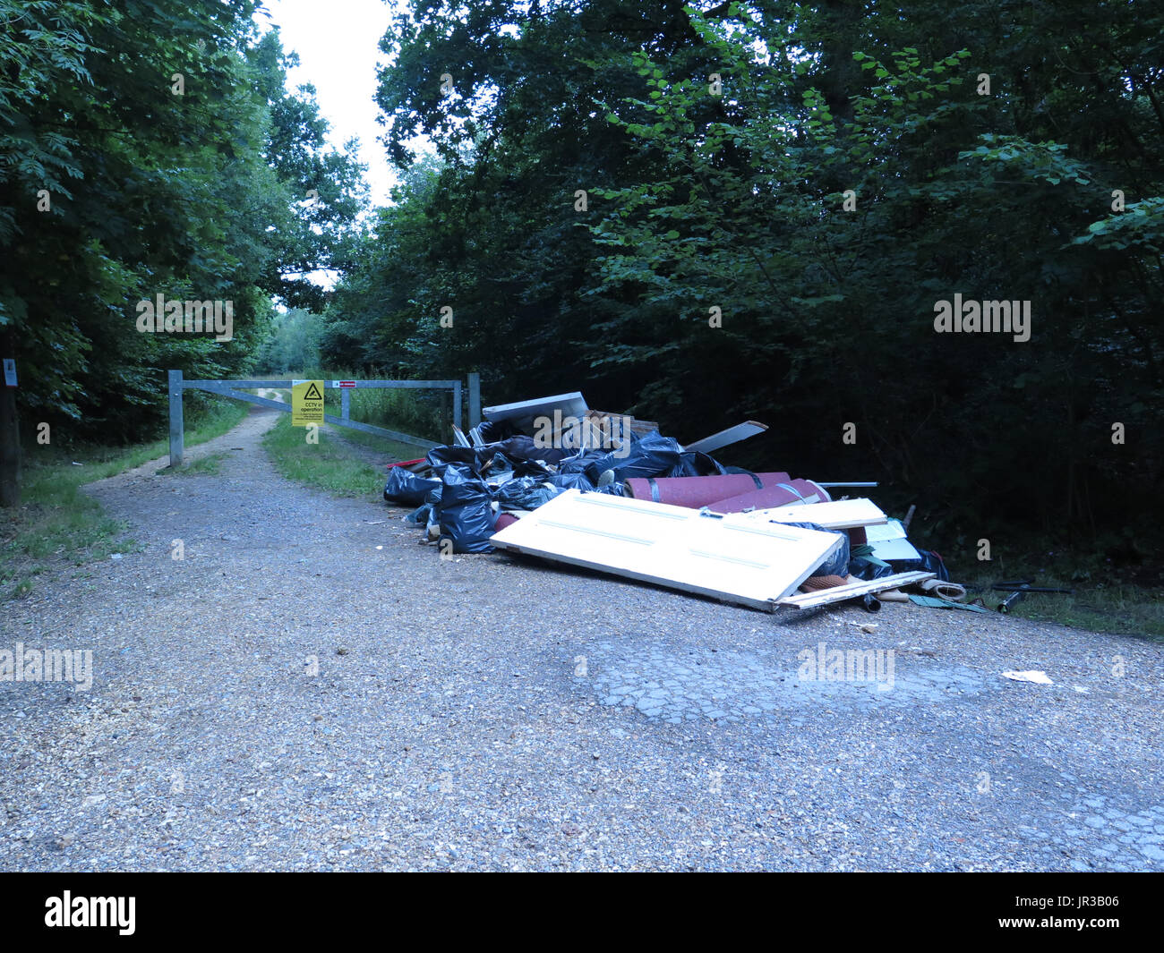fly-tipping under cctv sign Stock Photo - Alamy