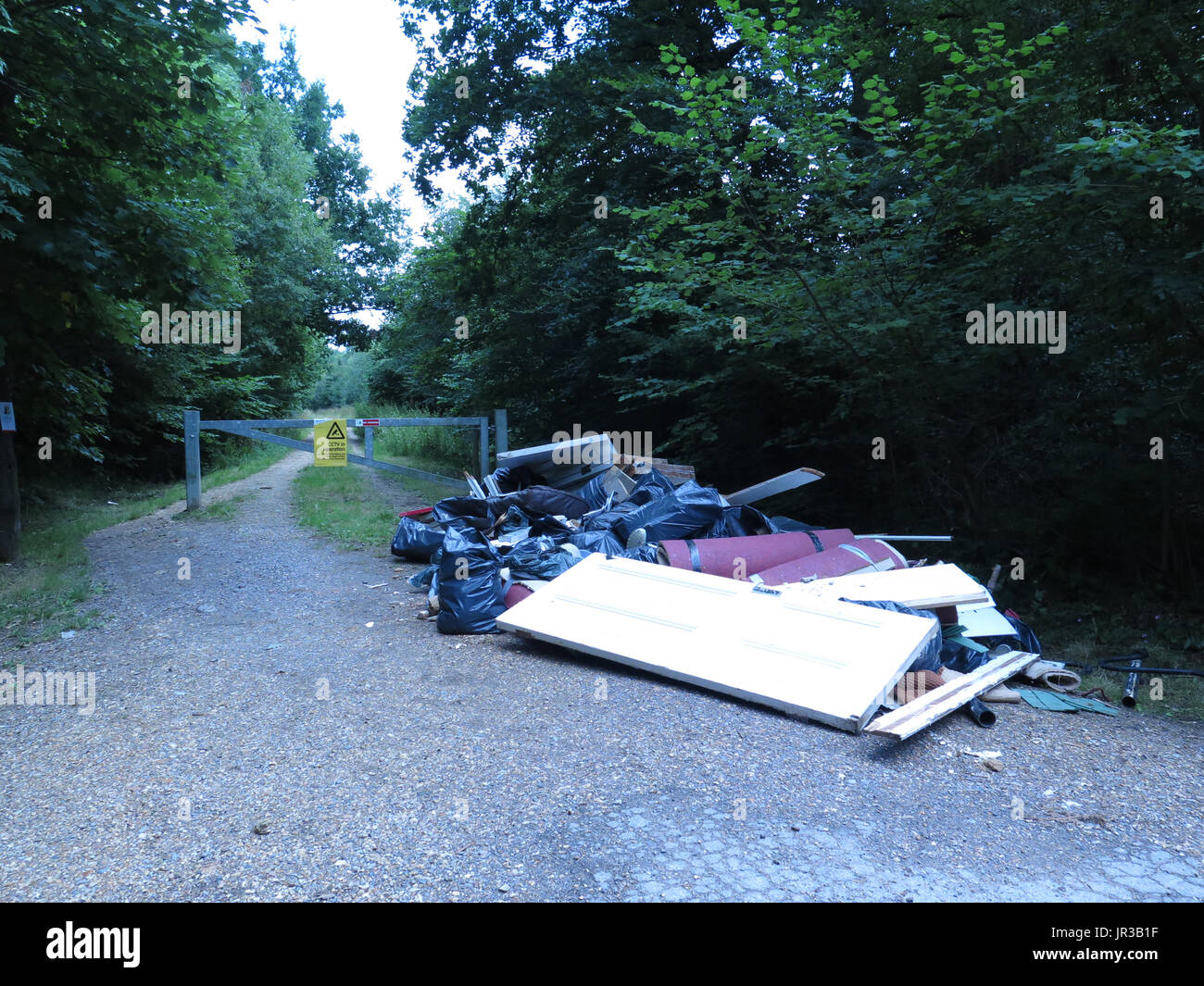 fly tipping under CCTV sign Stock Photo - Alamy