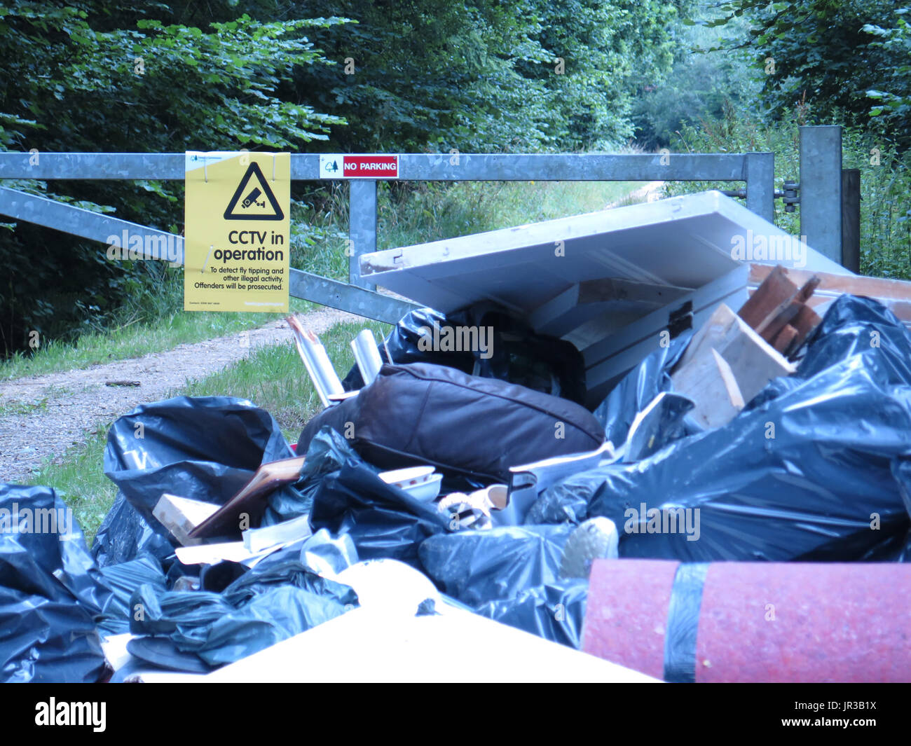 fly tipping under CCTV sign Stock Photo - Alamy