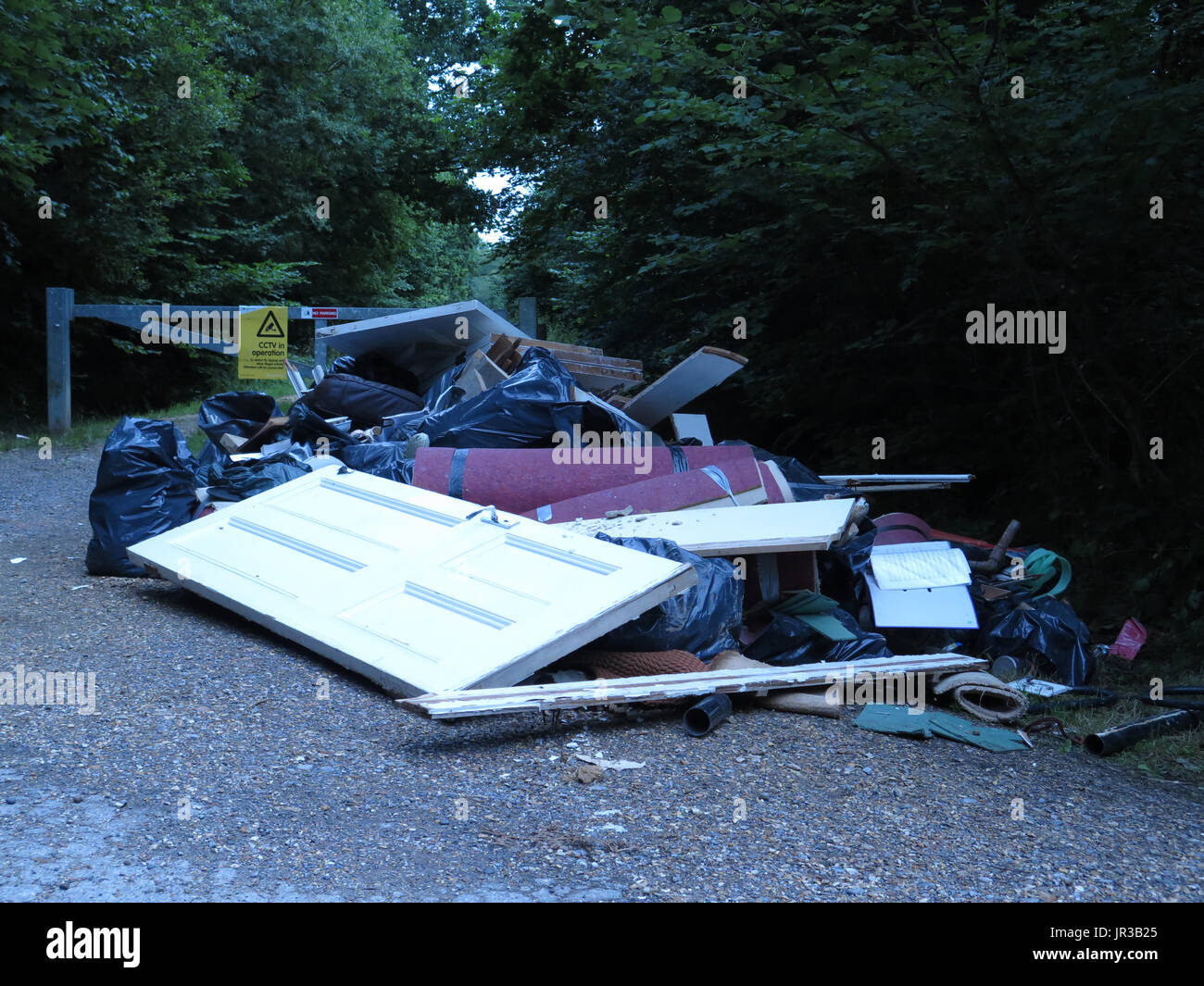 fly tipping under CCTV sign Stock Photo - Alamy