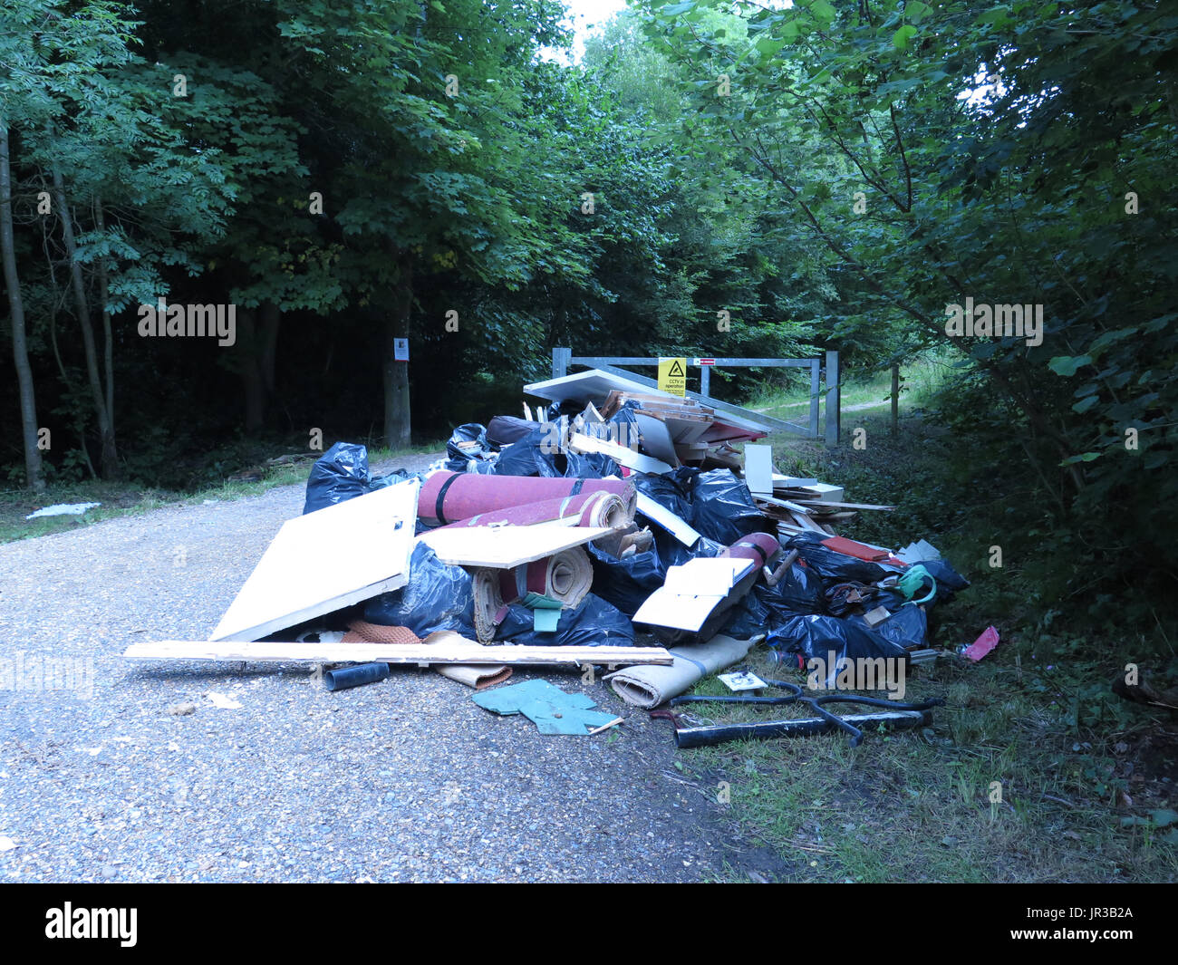 fly tipping under CCTV sign Stock Photo - Alamy