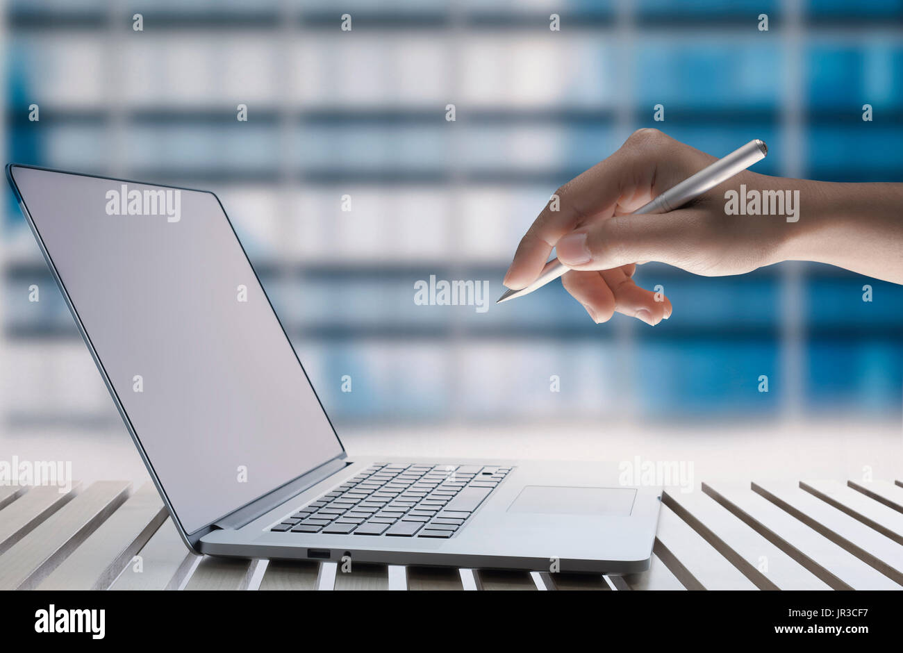 hand holding pen working on computer notebook Stock Photo - Alamy
