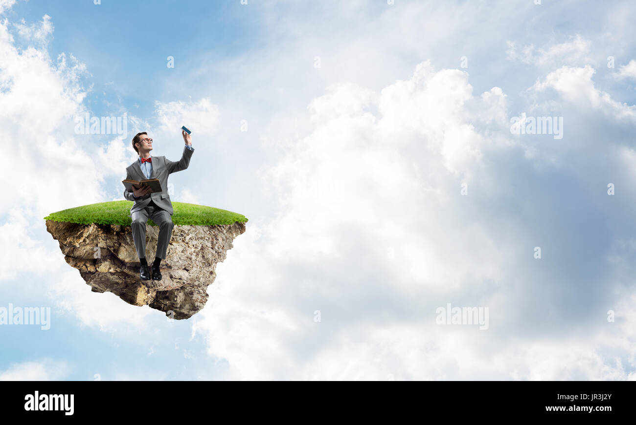 Young businessman or student floating in sky and studying the science ...