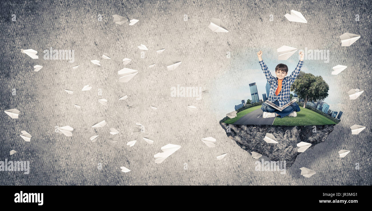 Cute boy of school age with book exploring this great world Stock Photo ...