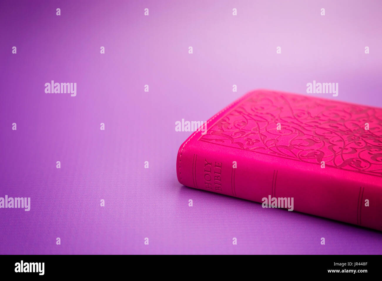 Closed Pink Bible on a Purple Background Stock Photo - Alamy
