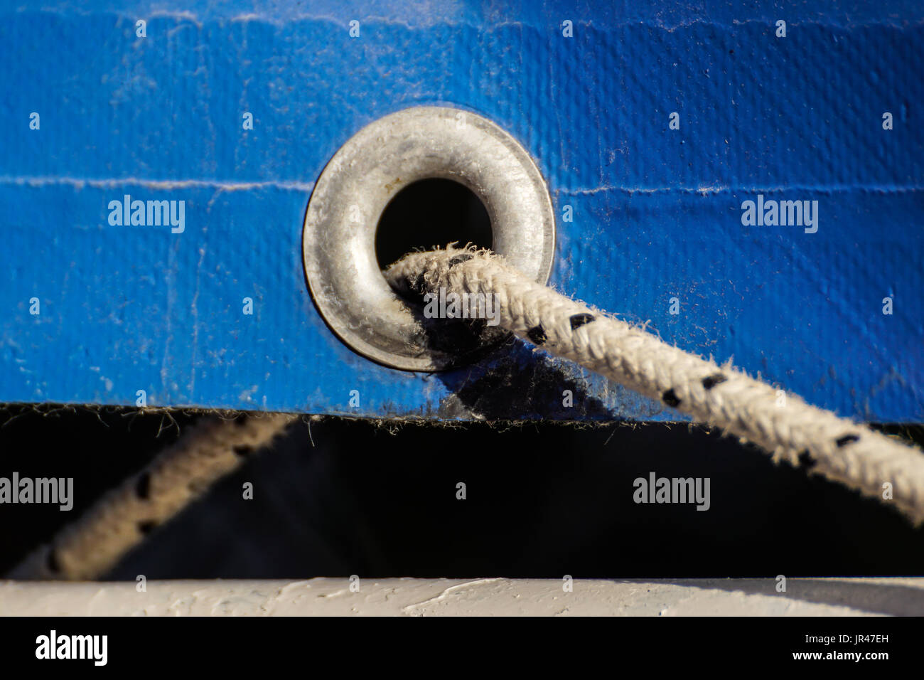 old rusty eyelets on an aged blue coated plastic canvas for ...