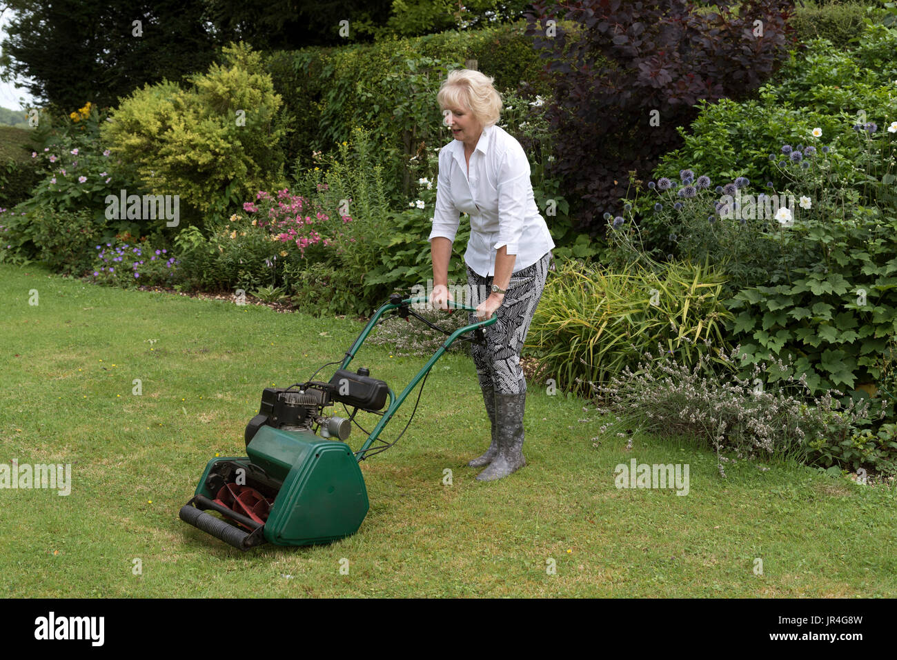Woman pushing lawn mower hi-res stock photography and images - Alamy