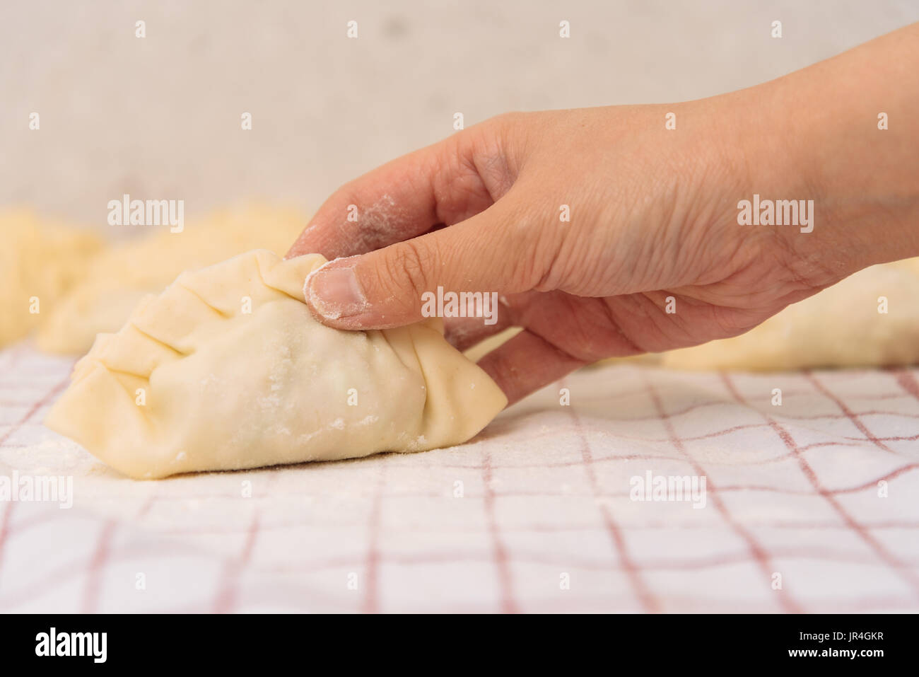 Female Hand moving a Handmade Dumpling Stock Photo - Alamy