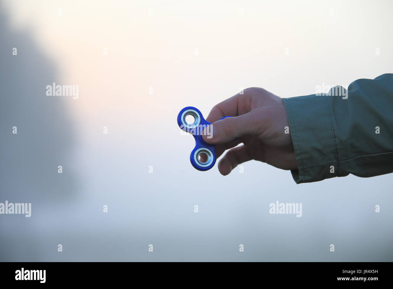 Fidget in man's hand on natural background Stock Photo - Alamy