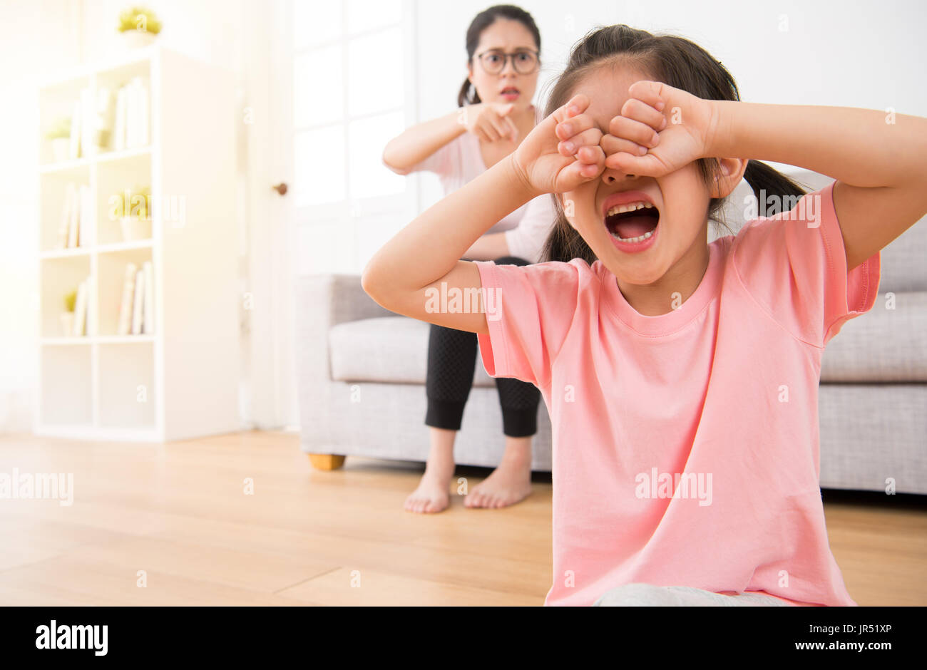 the sad little children girl sitting on the wooden floor crying loudly ...