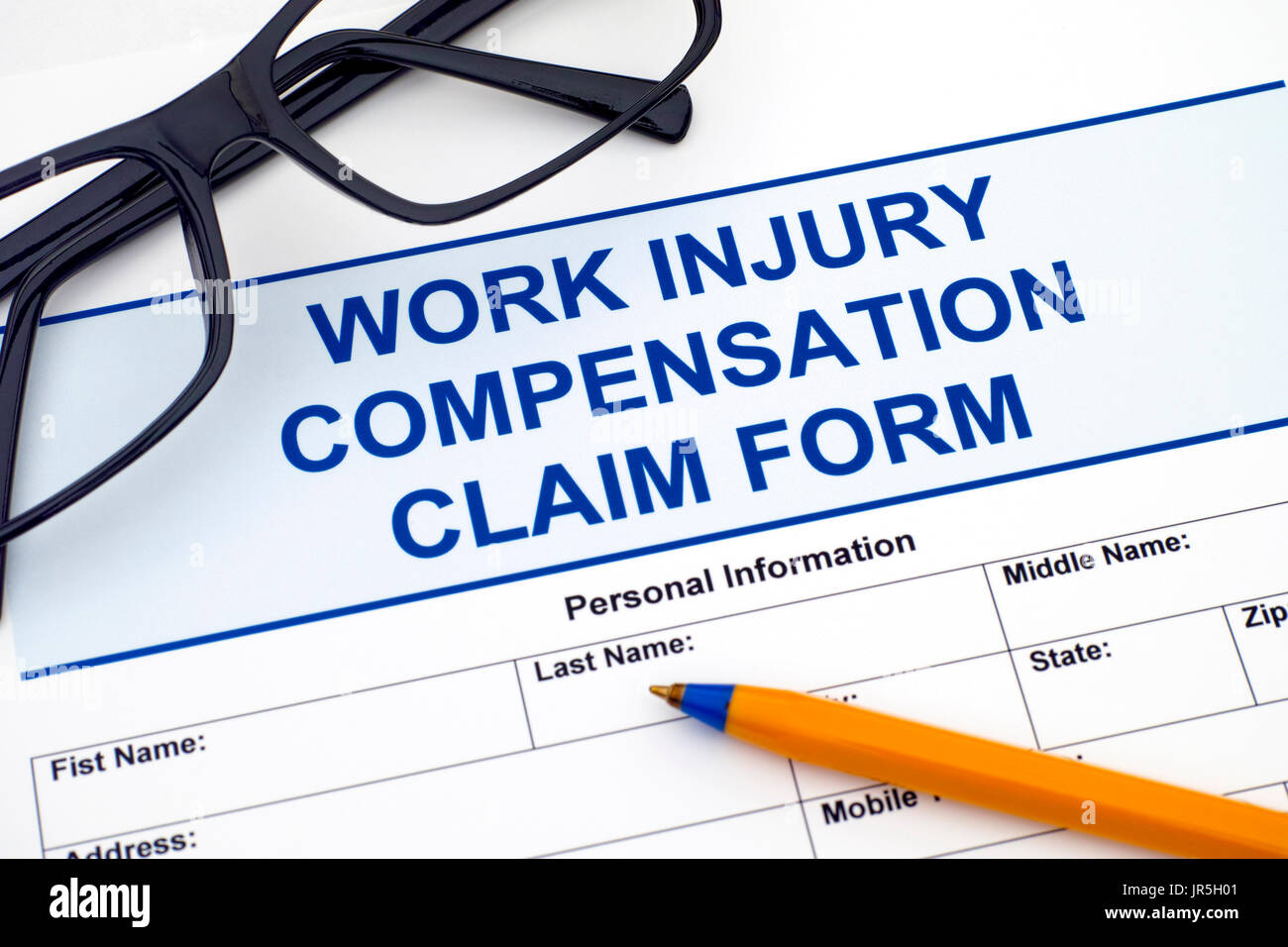 Work Injury Compensation Claim Form with ballpoint pen and glasses ...