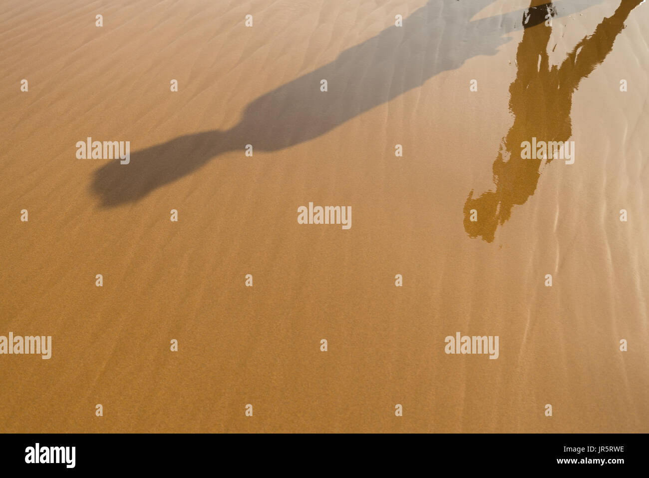 Double shadow on sand Stock Photo - Alamy