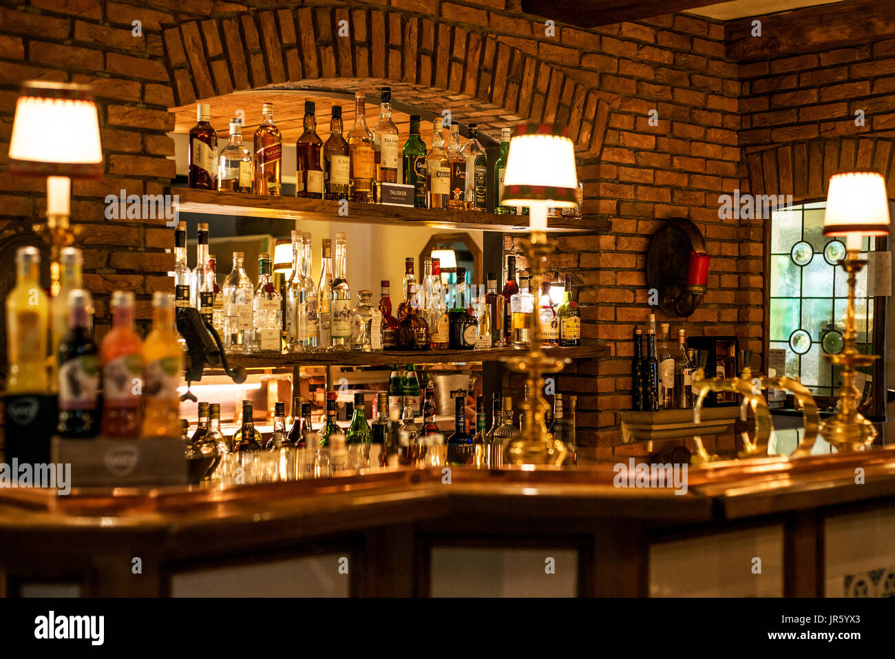 Bitters and infusions on bar counter, bottles in blurred background ...
