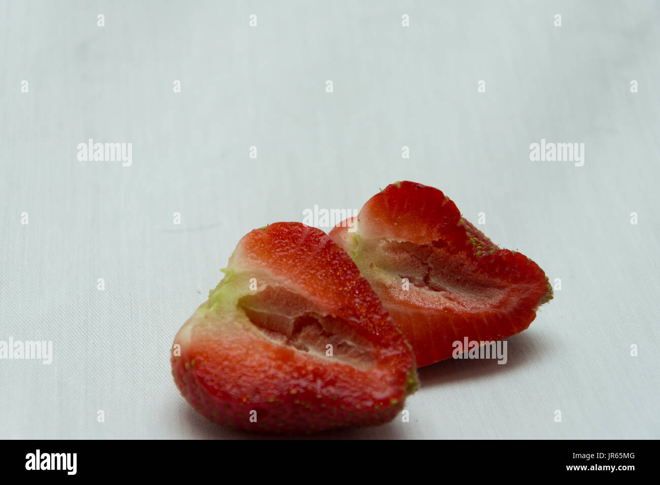 close up of a cut up strawberry on a white background Stock Photo - Alamy