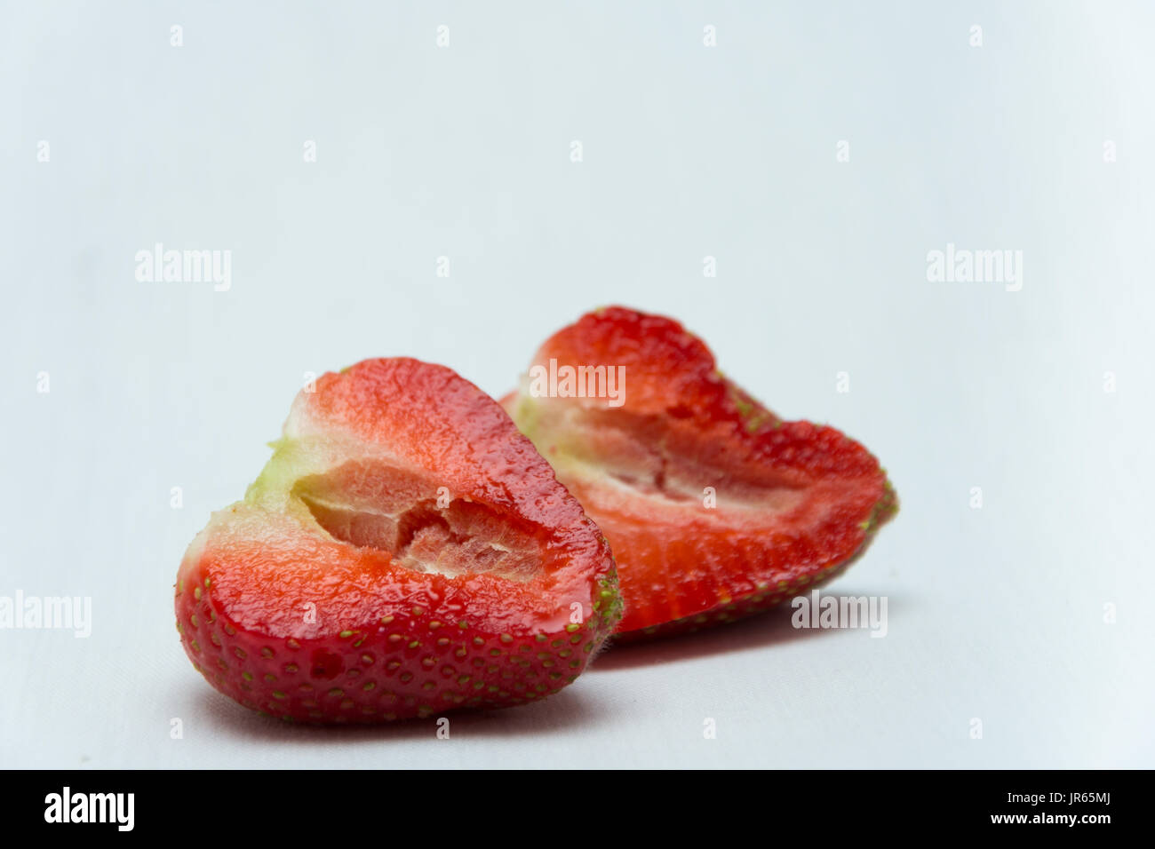 close up of a cut up strawberry on a white background Stock Photo - Alamy