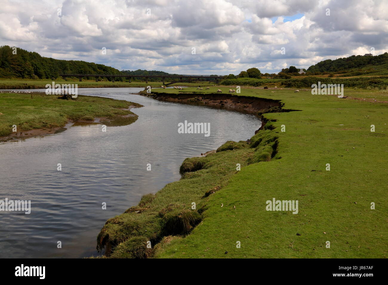 The river Ogmore (Aberogwr) flowing out towards the ocean with green ...
