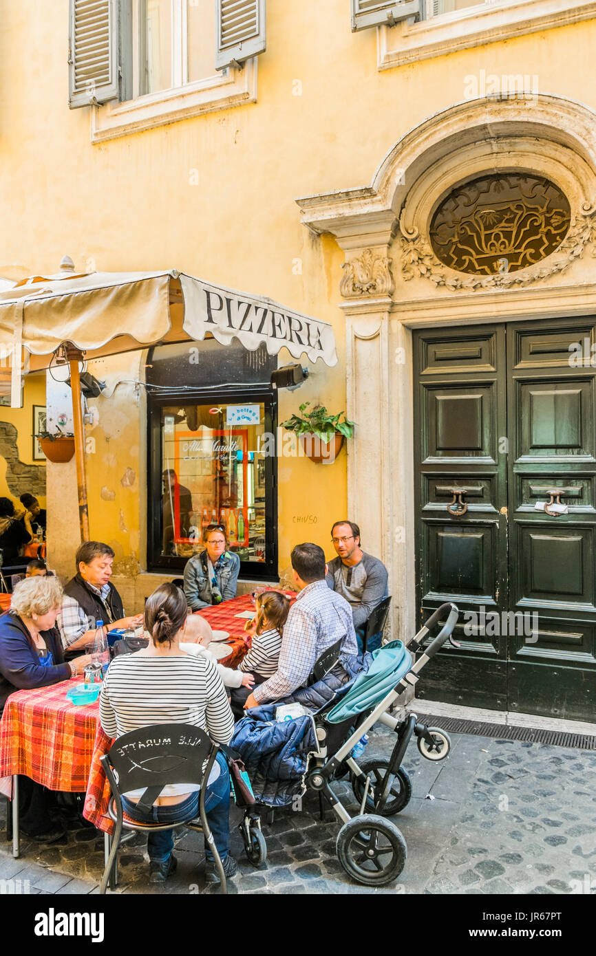 roman family having lunch at restaurannt pizzeria alle muratte seated ...
