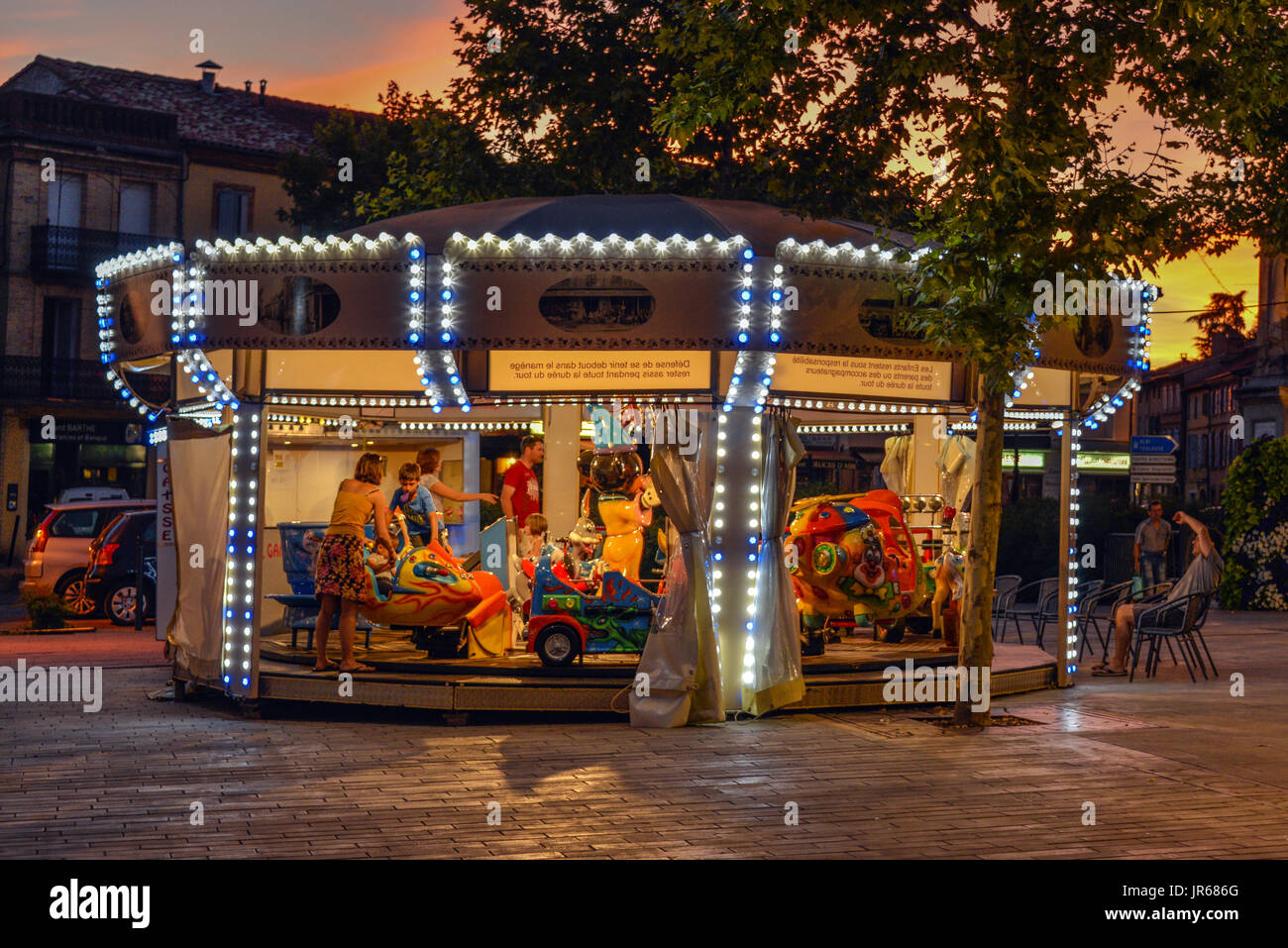 Summer fair ride at dusk, in the French, Occitanie city of Gaillac ...