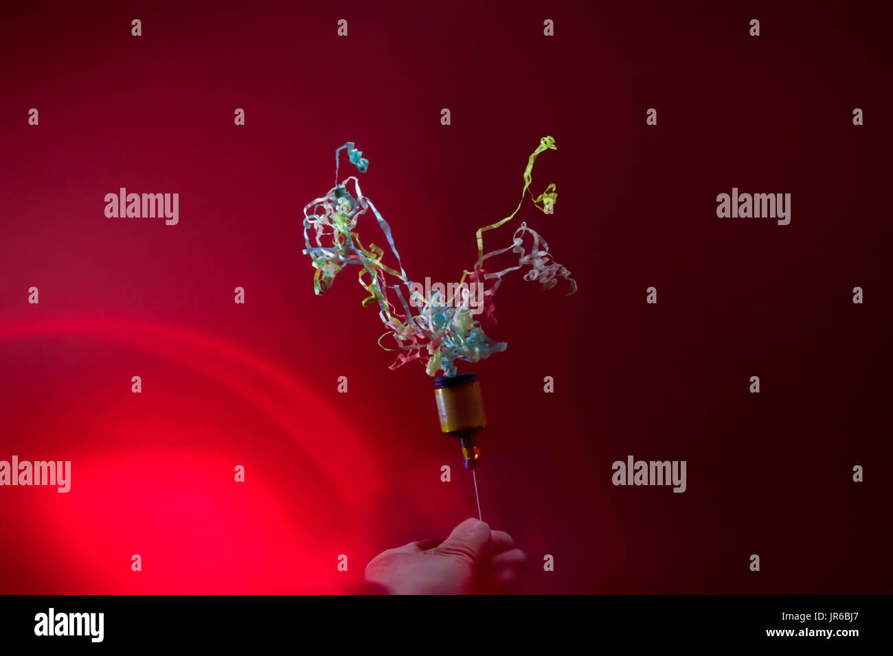 Hand holding a party popper Stock Photo - Alamy