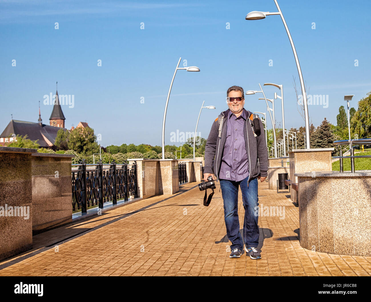 Man walking along waterfront with his camera Stock Photo - Alamy