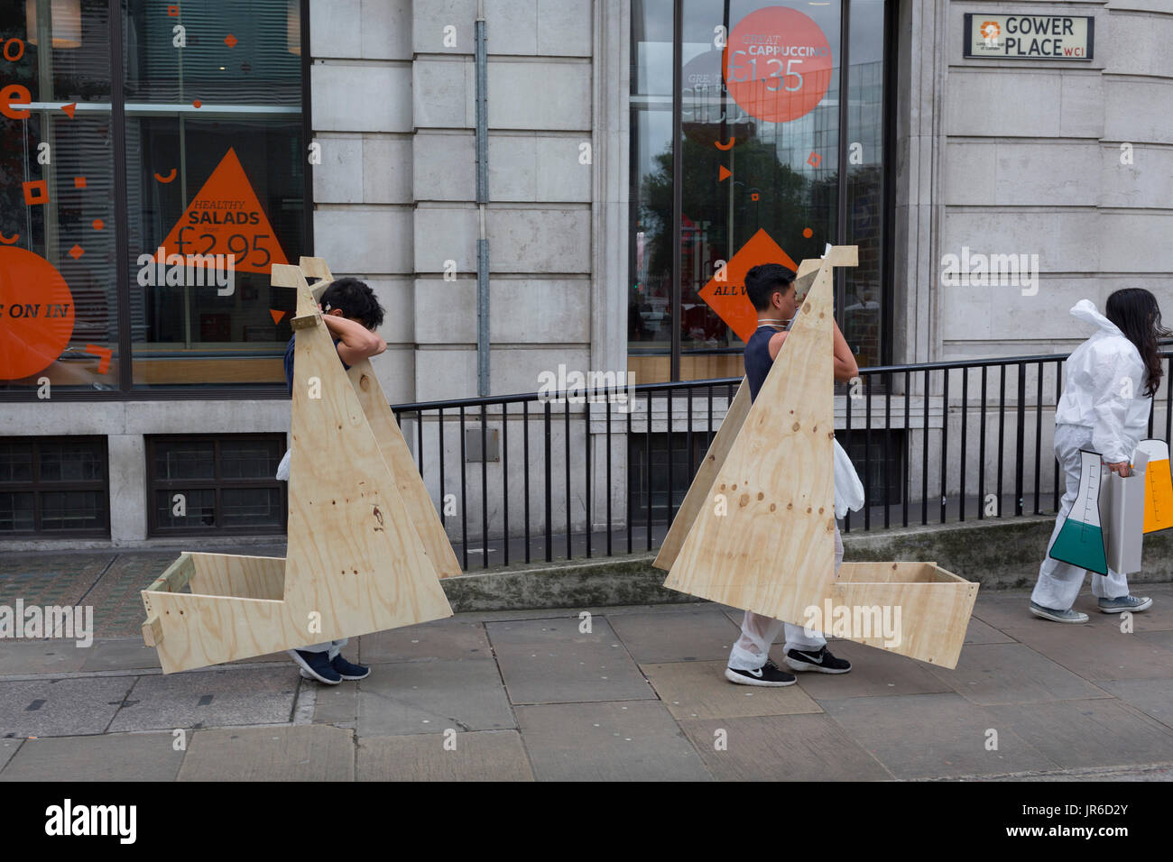 Architecture students carry awkward plywood cut-out shapes as part of ...