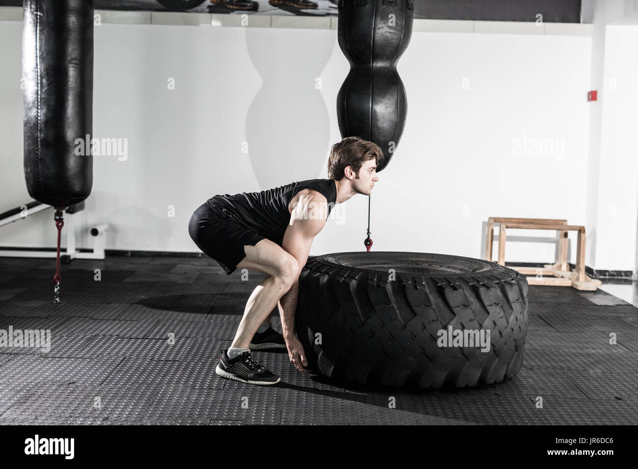Workout with a big tire in fitness gym Stock Photo - Alamy