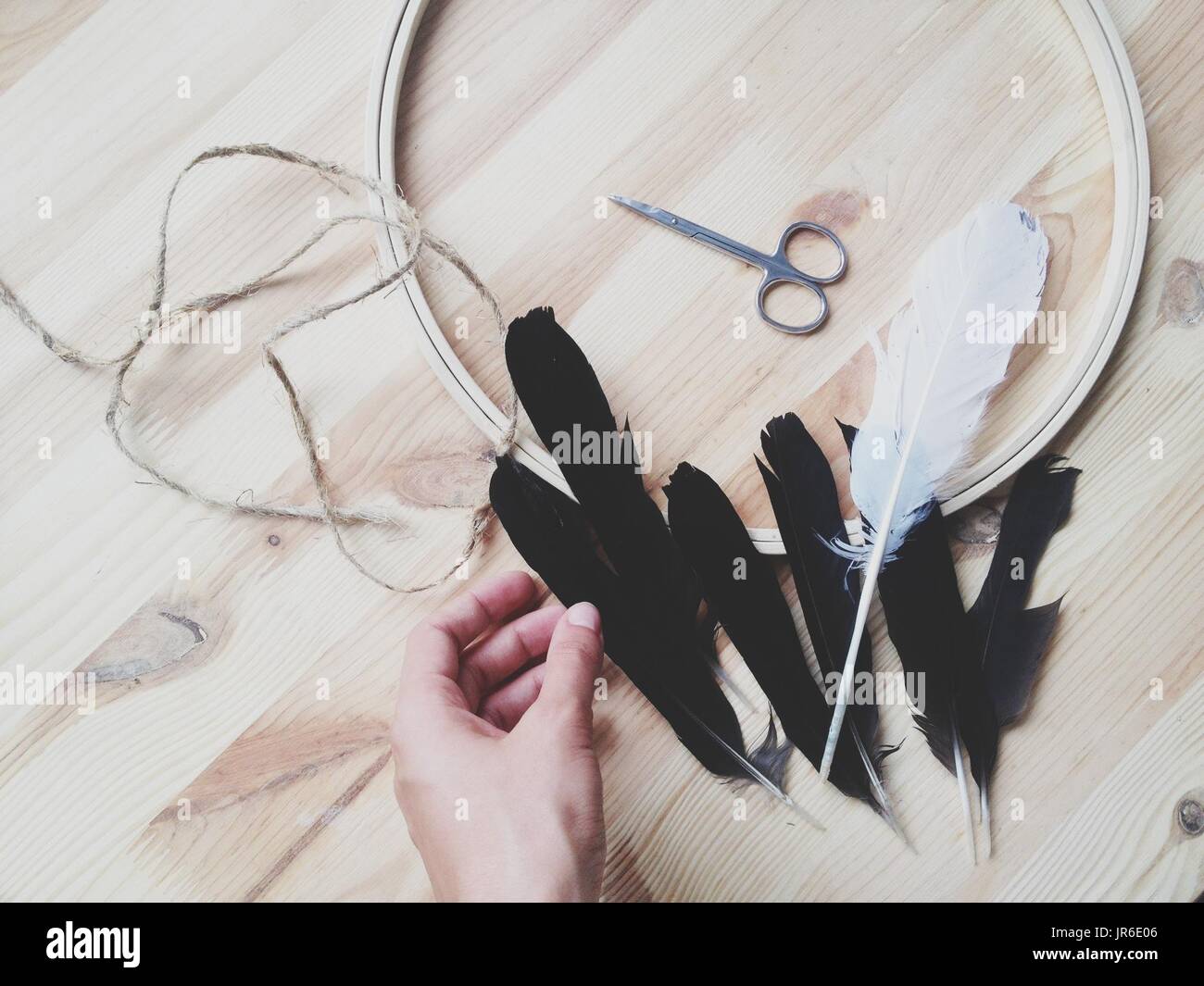 Wooden embroidery hoop, feathers, string and scissors Stock Photo - Alamy