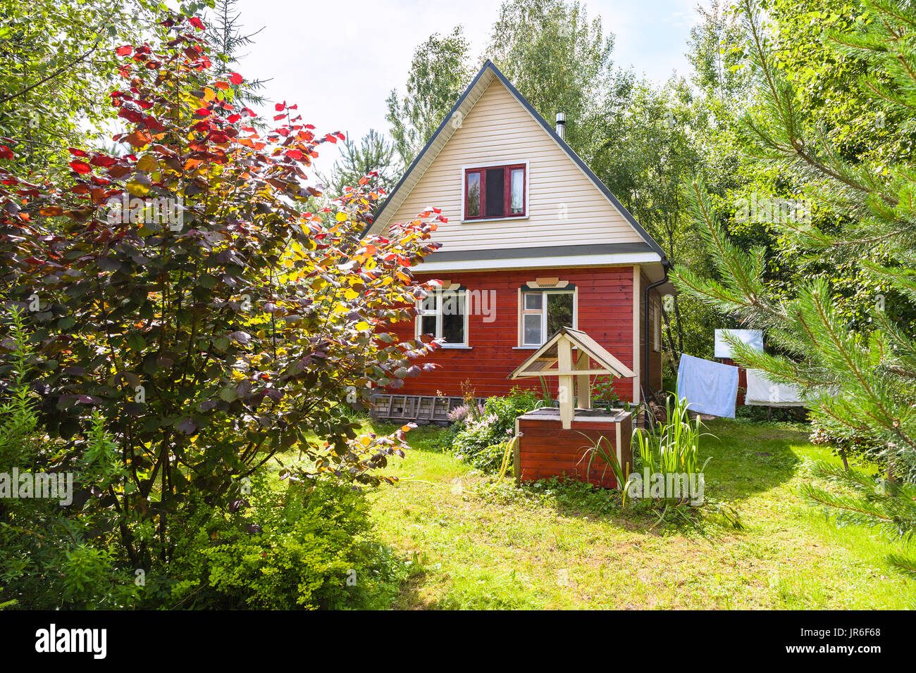 new cottage and well on backyard in russian village in sunny summer day ...
