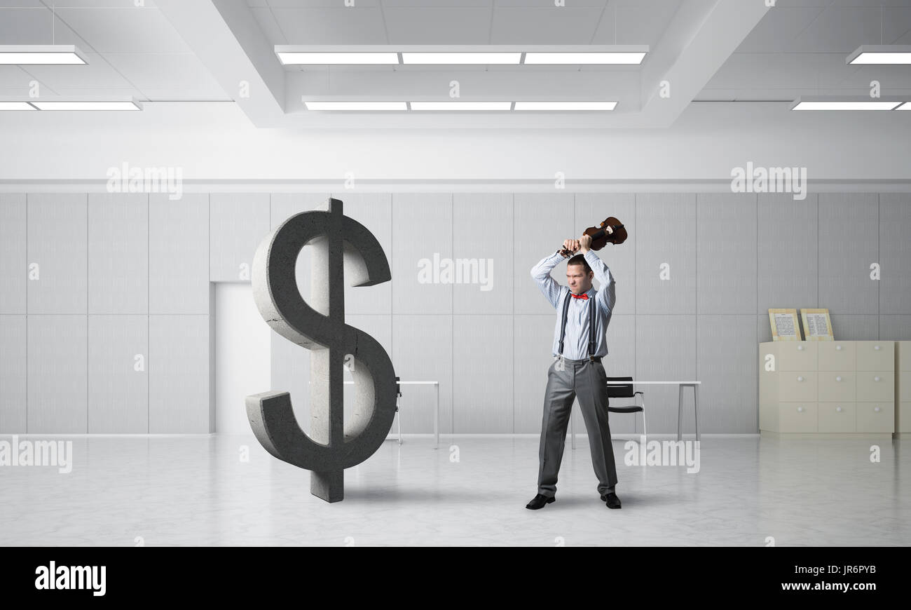 Determined banker man in modern office interior breaking dollar figure ...