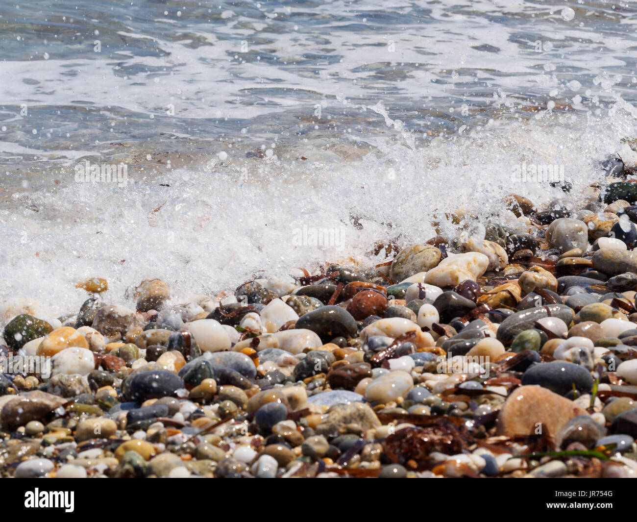 Wet pebbles on a sea shore Stock Photo - Alamy