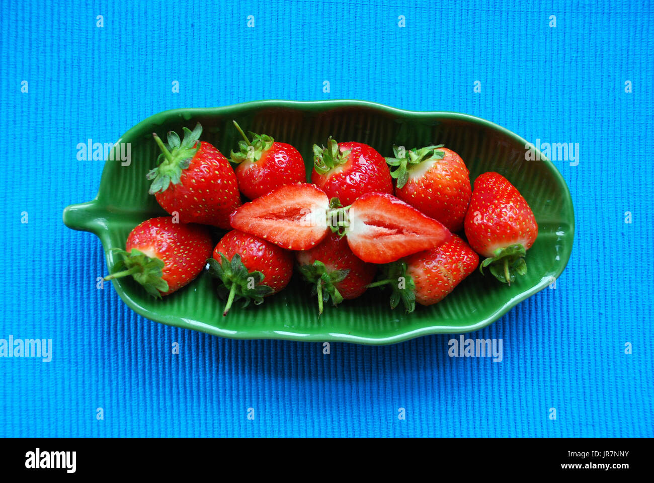 Vibrant, high contrast fruit. whole strawberries placed on a banana ...
