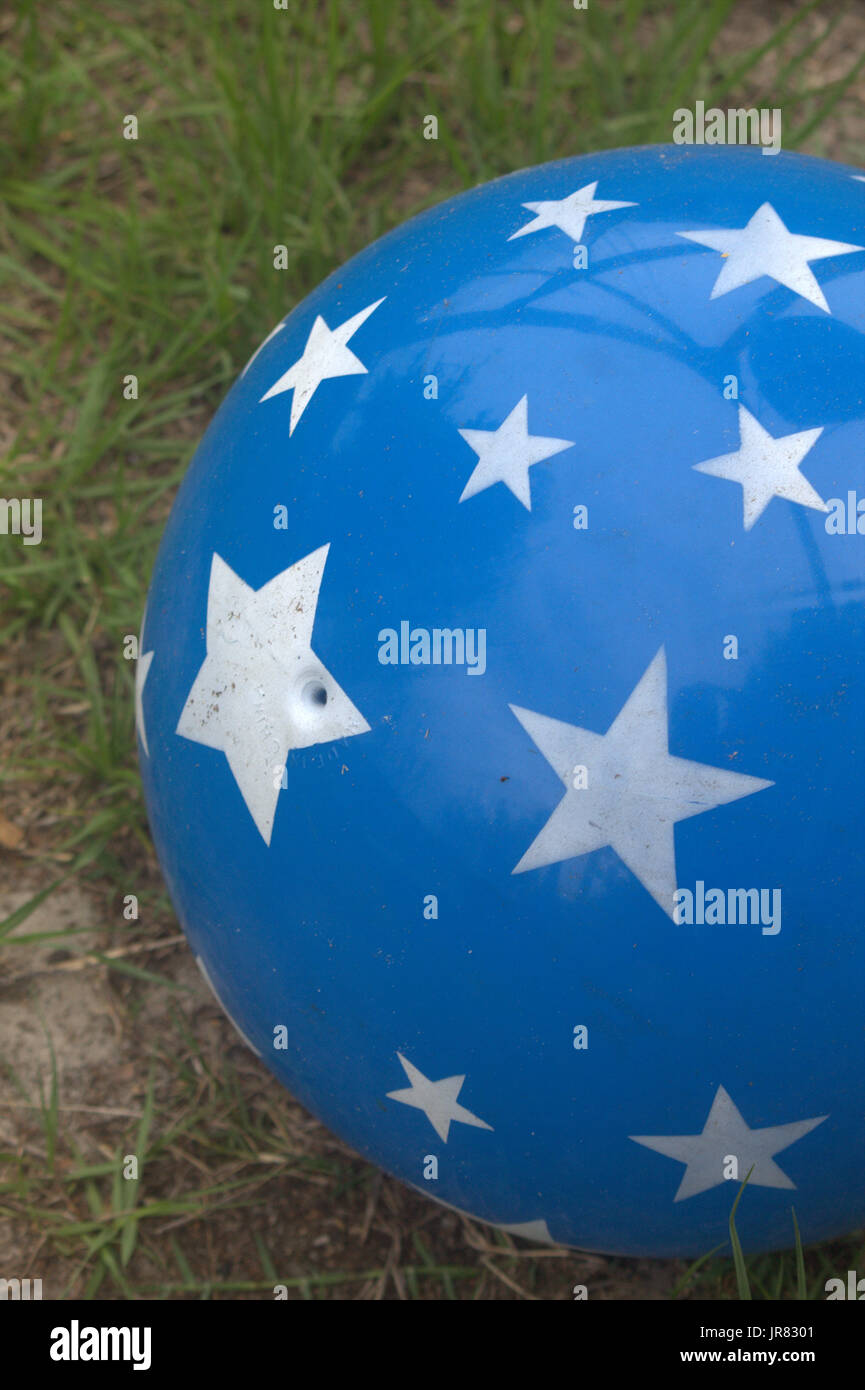 Bright blue ball with white stars with green grass background Stock ...