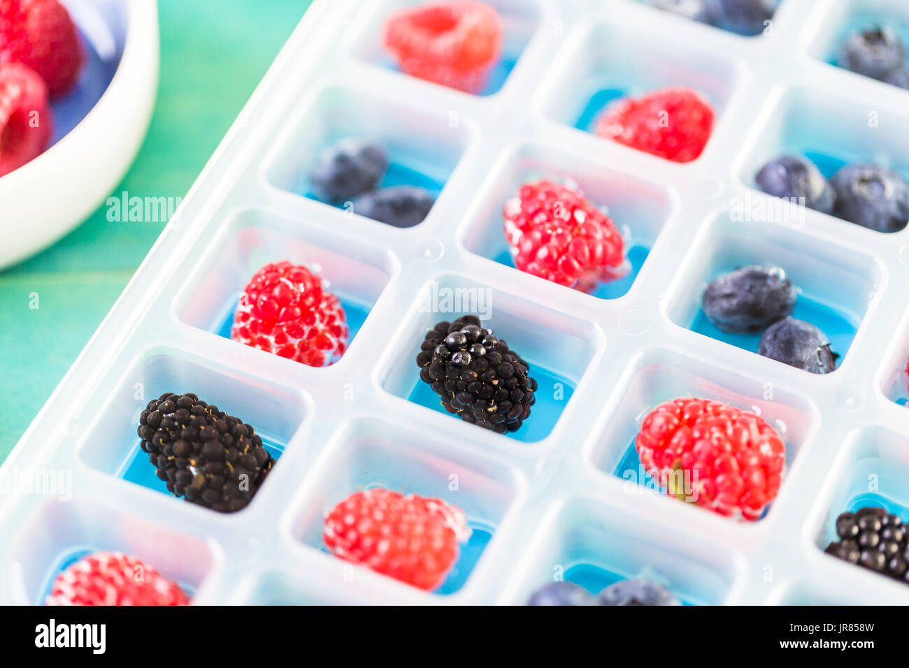 Making fresh fruit ice cubes for summer drink Stock Photo - Alamy