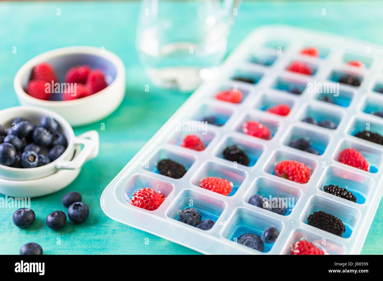 Making fresh fruit ice cubes for summer drink Stock Photo - Alamy