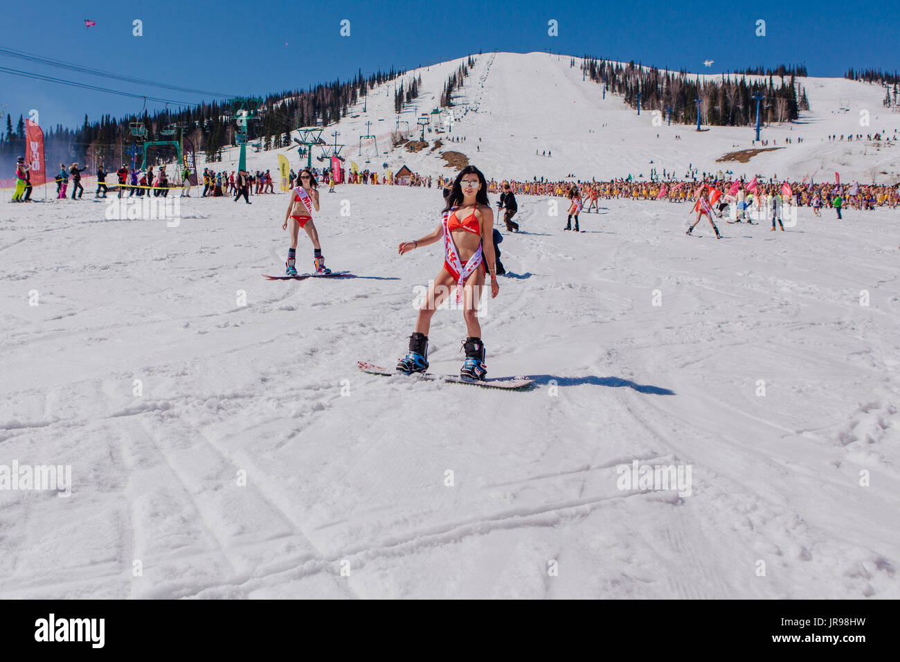 Group of young happy pretty women on a snowboard in colorful bikini ...