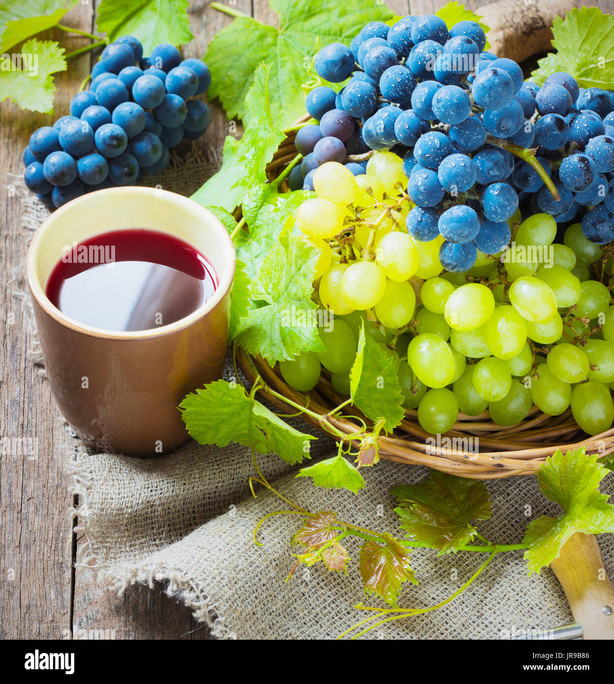 red wine and grapes. Wine and grapes in vintage setting with corks on ...