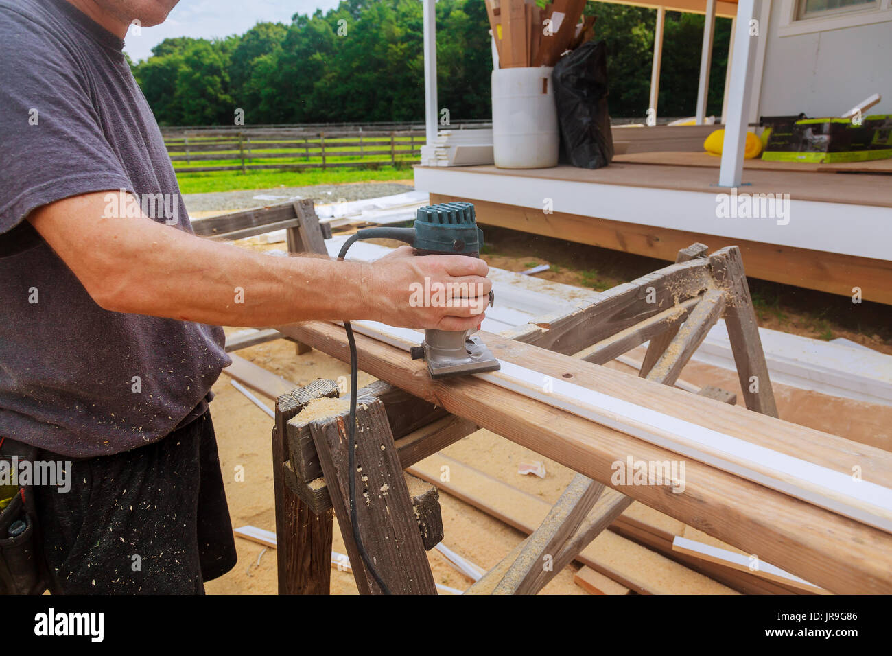 electric hand held power fixed base router with work gloves on wood ...