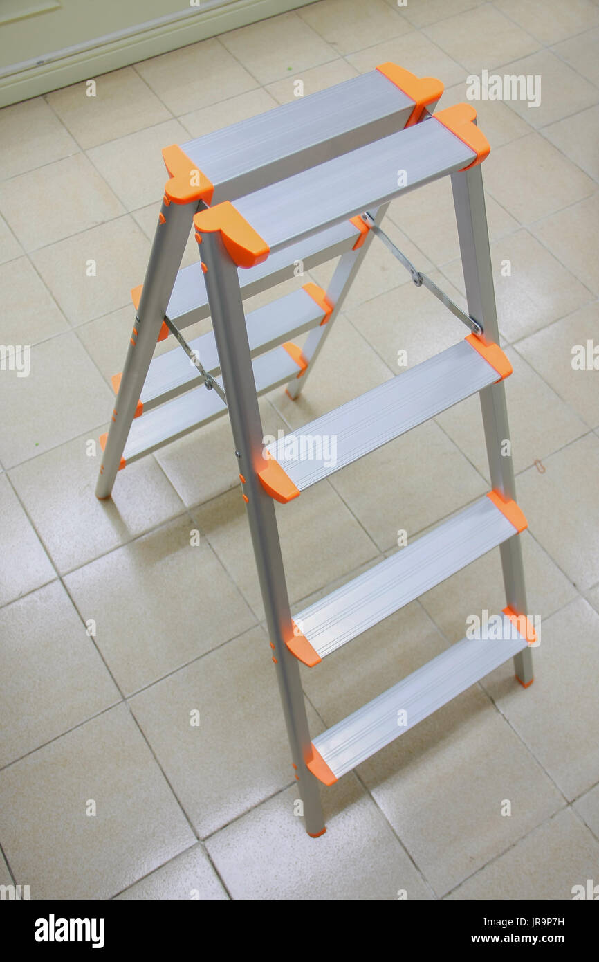 orange aluminum folding ladder, stepladder on tile floor for general ...