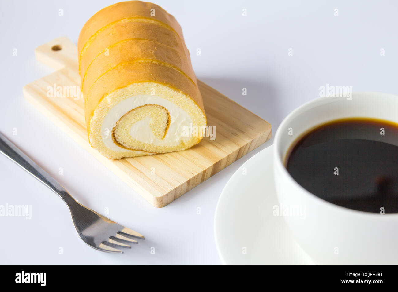 Swiss roll and coffee on white background Stock Photo - Alamy