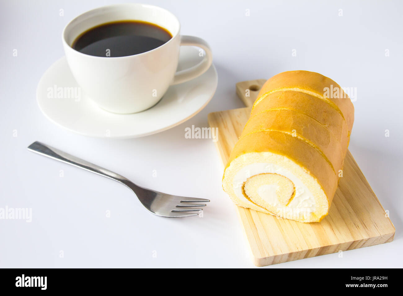 Swiss roll and coffee on white background Stock Photo - Alamy