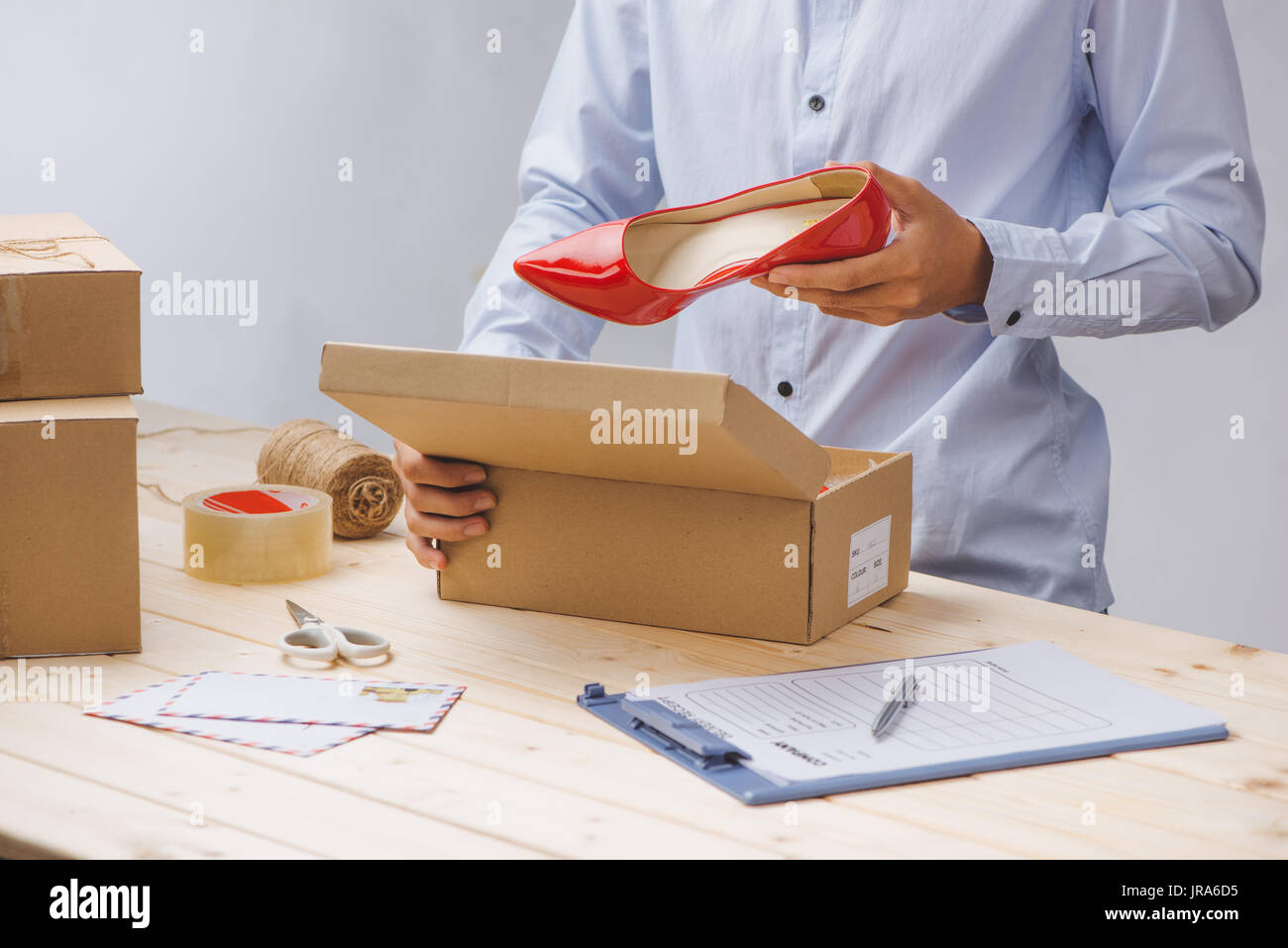 Close up deliveryman checking supplies and putting on cardboard box ...