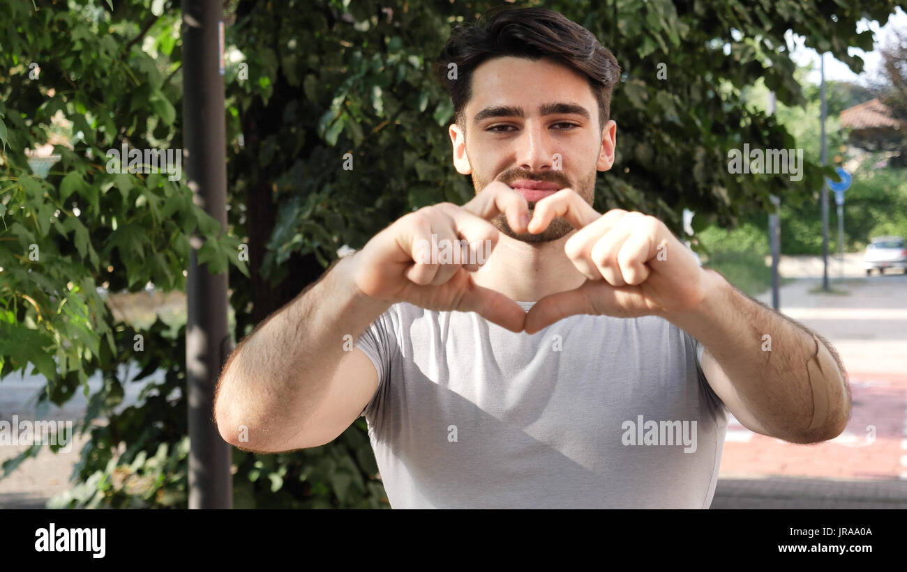 Young man making heart sign with his hands Stock Photo - Alamy